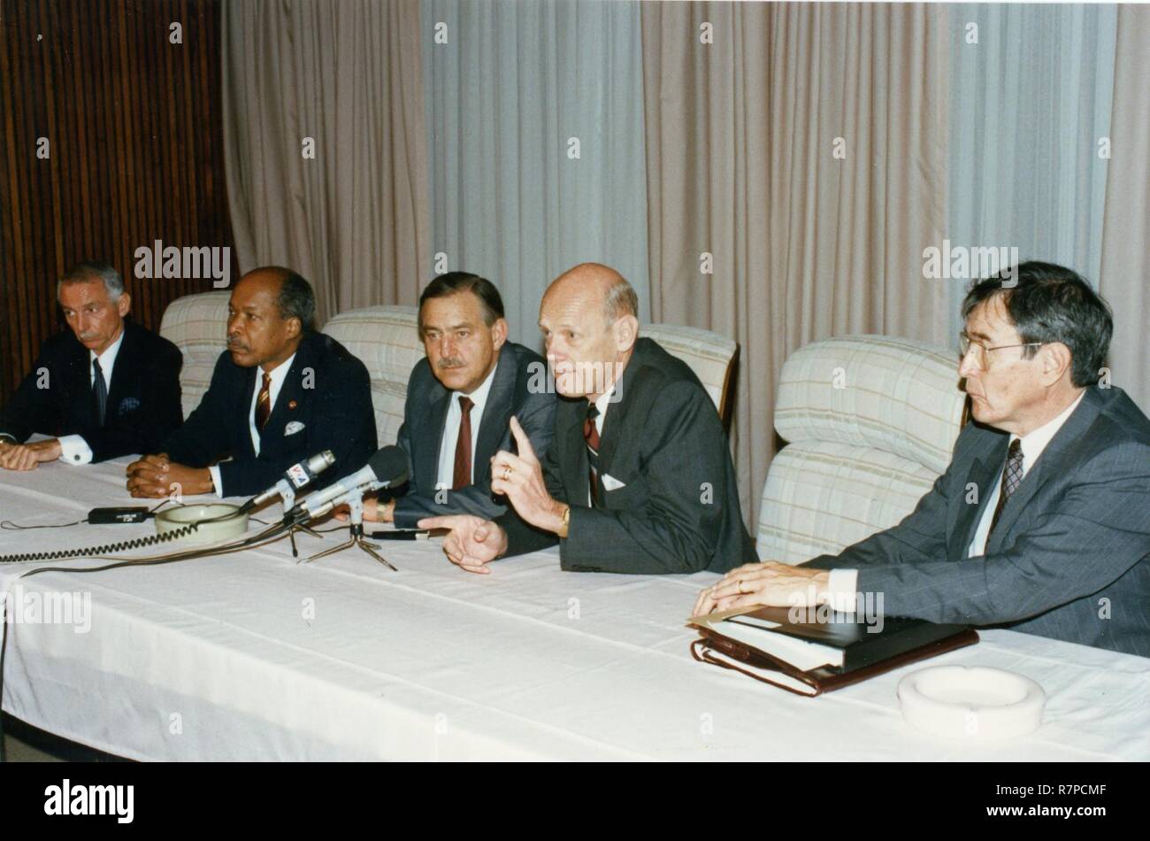FIVE MEN SITTING AT THE TABLE HAVING A CONVERSATION WITH SOME OTHER ...