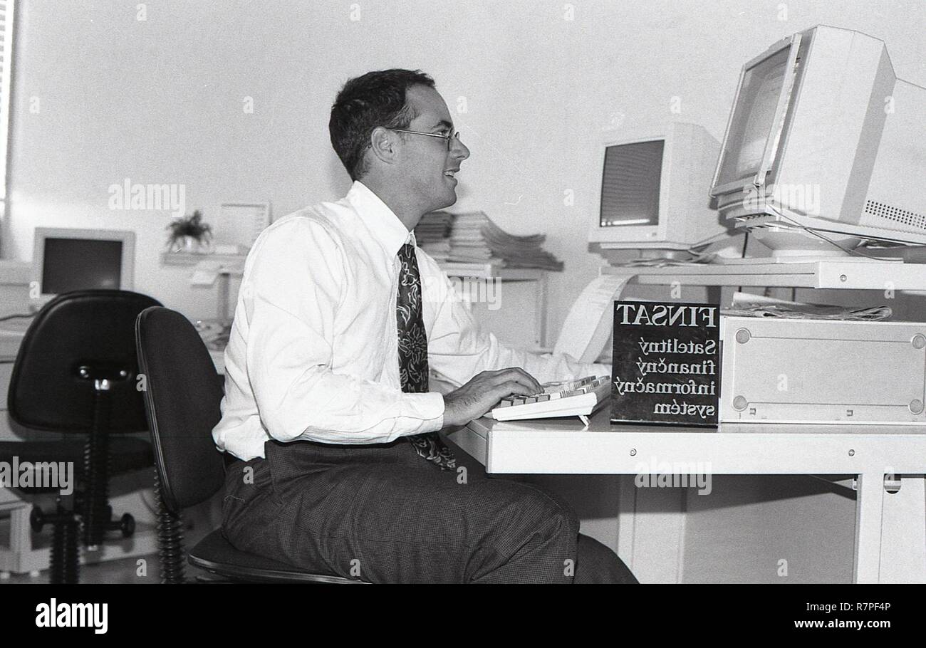 A MAN SITTING AT HIS DESK LOOKING AT HIS COMPUTER Stock Photo - Alamy