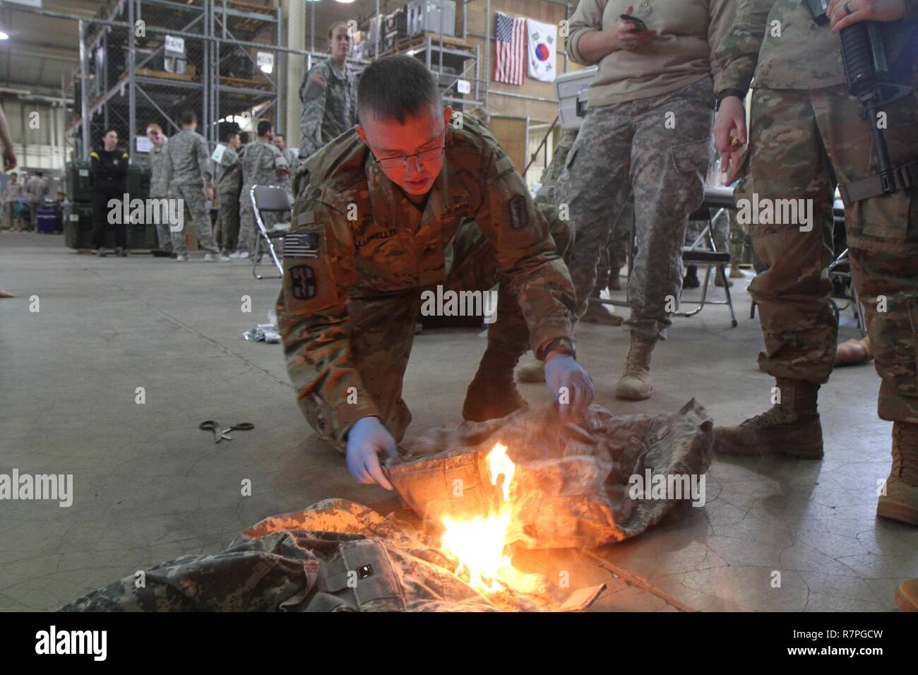A member of the 121st Combat Support Hospital lights an old uniform on ...