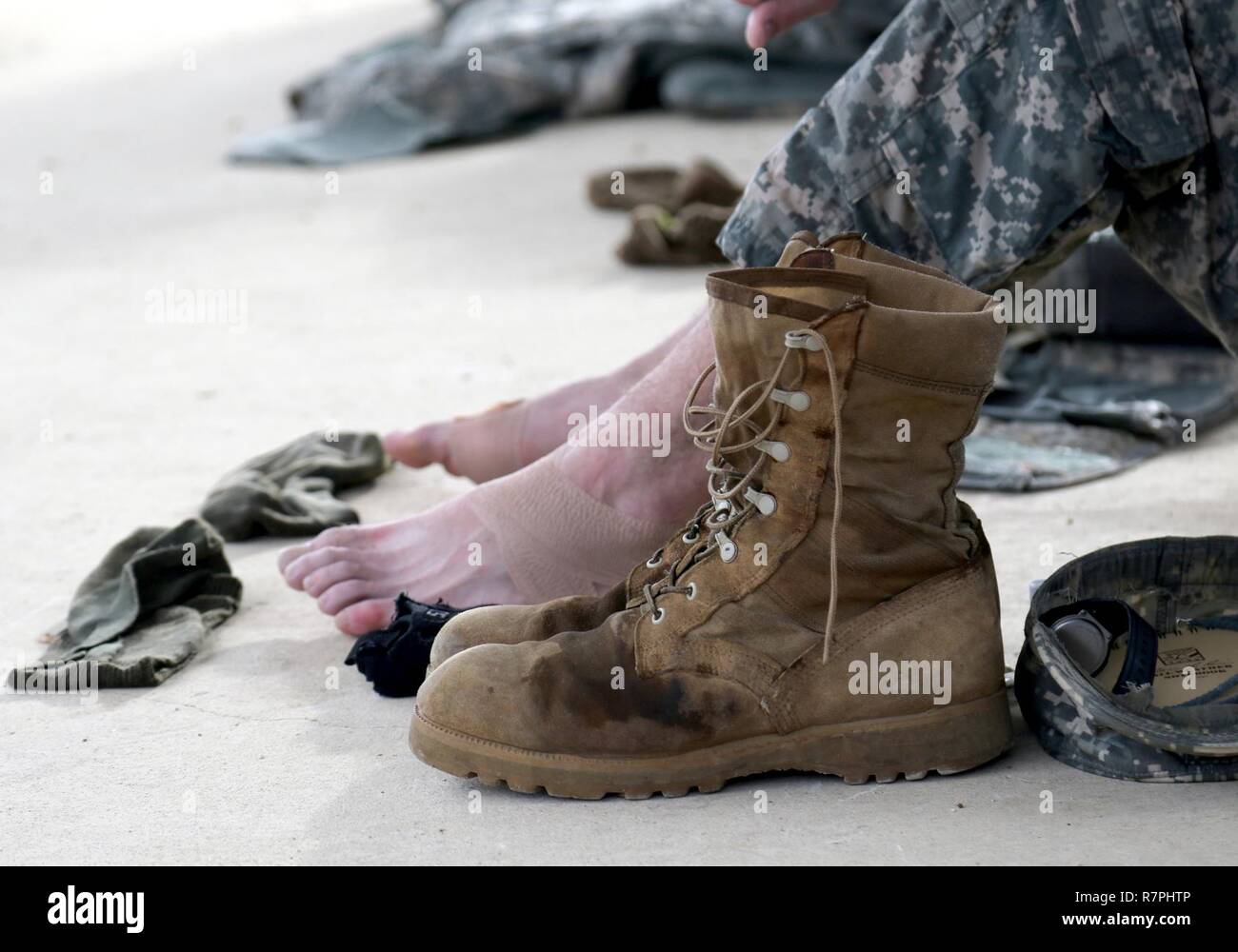 An Army Reserve competitor rests and airs out his boots after a road ...