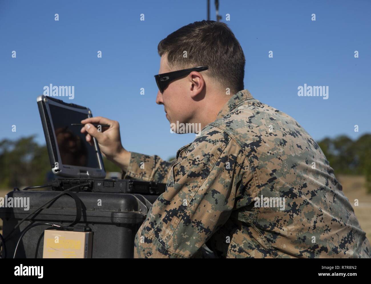 Sgt. Kyle Phillips configures computer equipment to ensure ...
