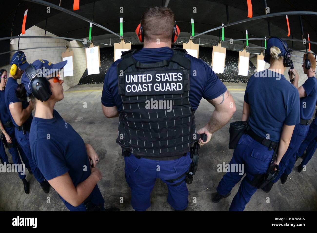 Coast Guard crewmembers prepare to conduct a live fire exercise during ...
