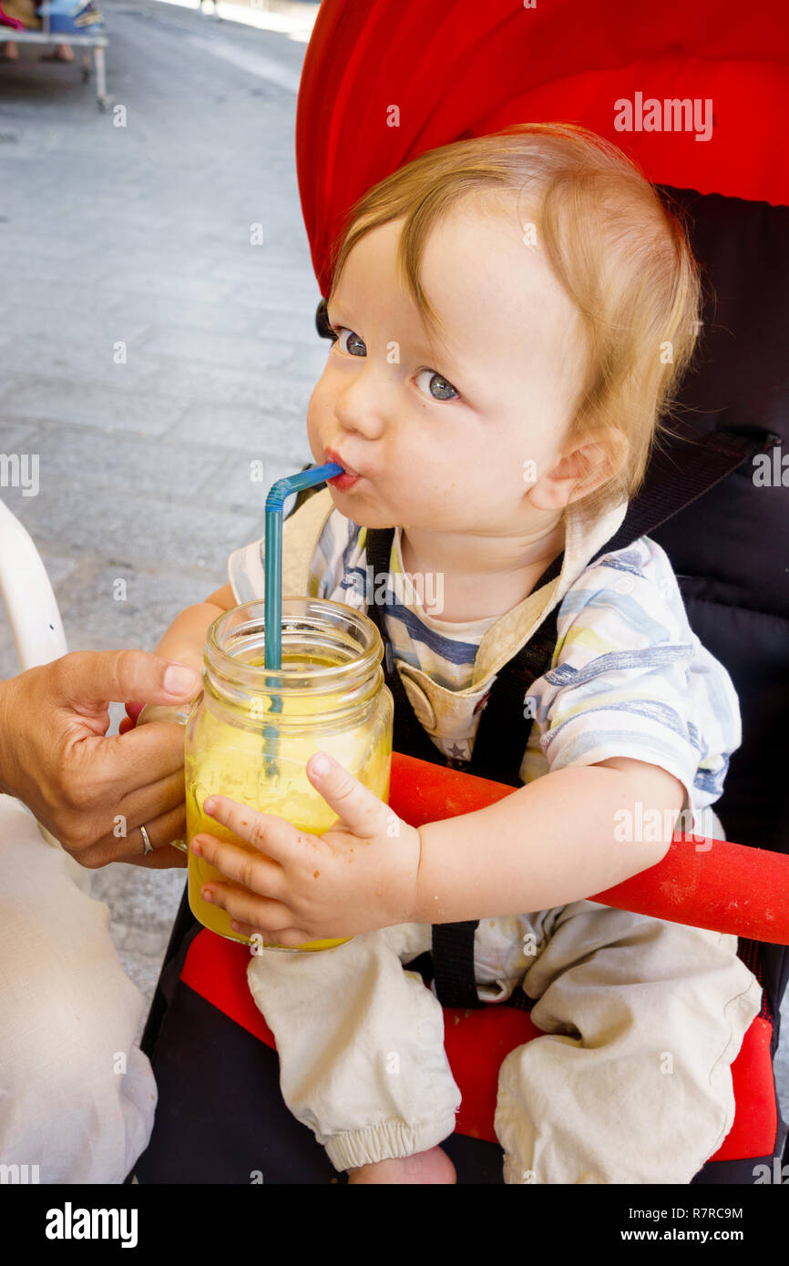 Portrait of baby boy drinking juice Stock Photo - Alamy