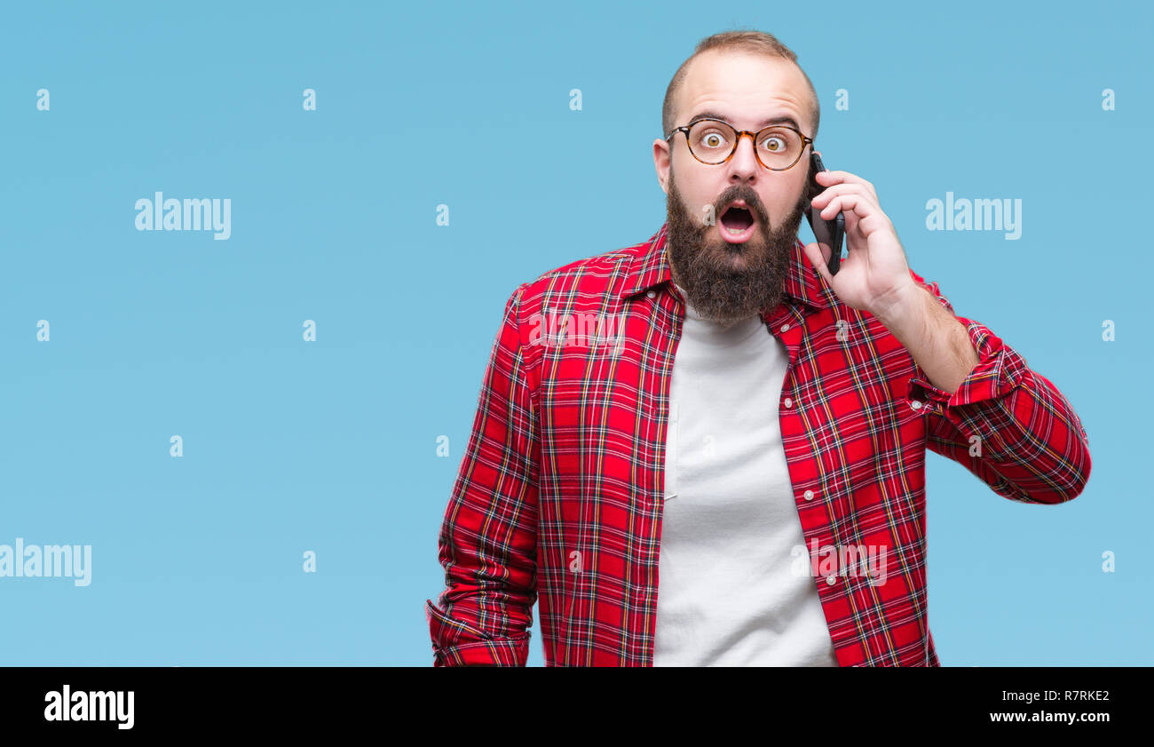 Young caucasian hipster man talking on smartphone over isolated ...