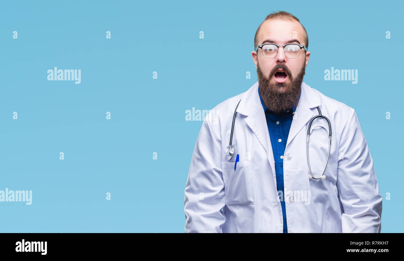 Young caucasian doctor man wearing medical white coat over isolated ...