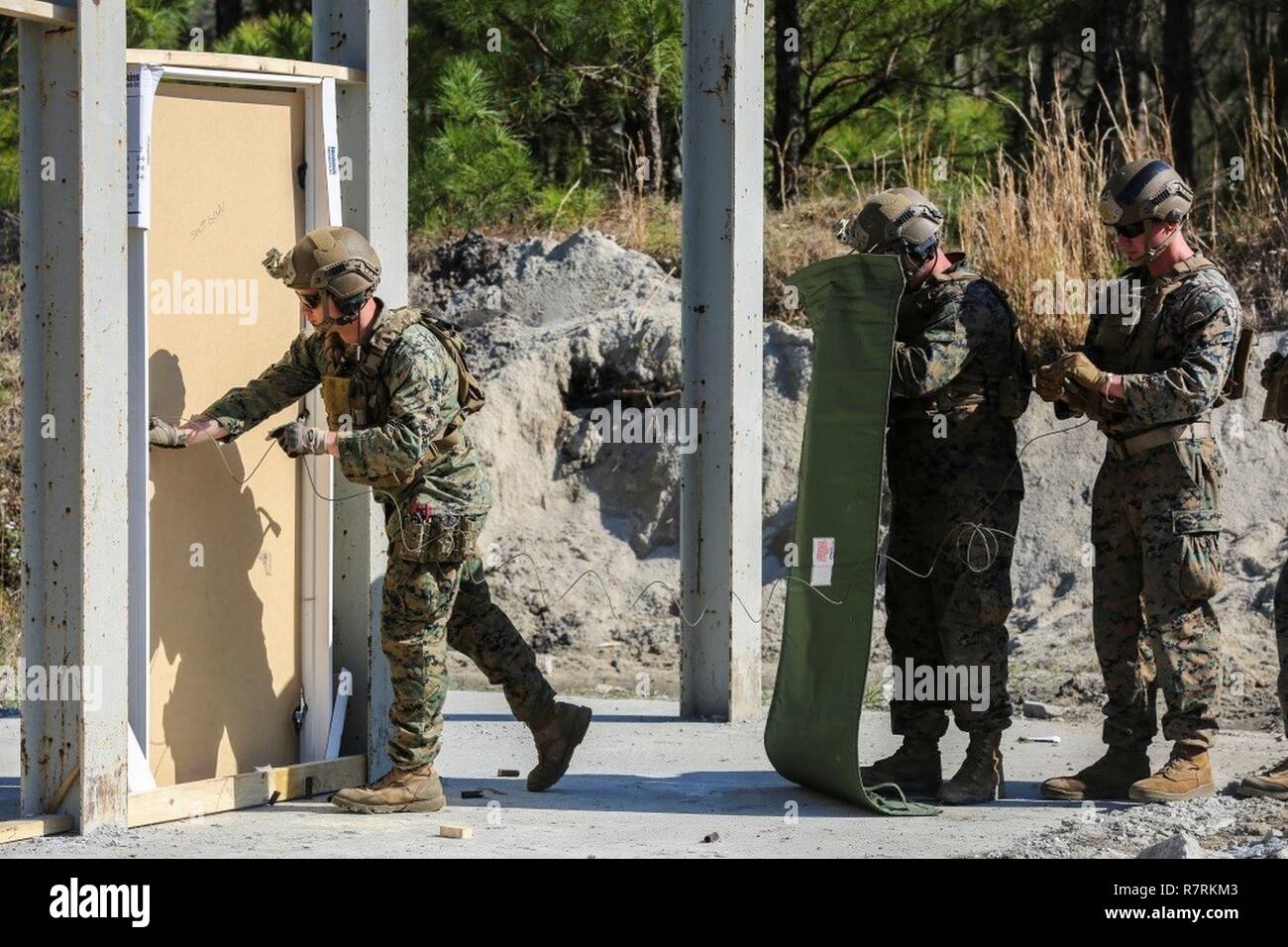 A Marine sets an explosive charge on a door during a breaching exercise ...
