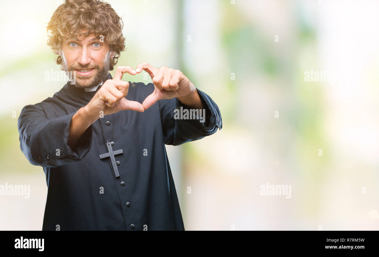 Handsome hispanic catholic priest man over isolated background smiling ...