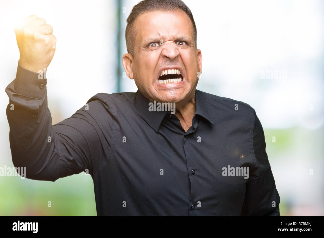 Handsome middle age arab business man over isolated background angry ...