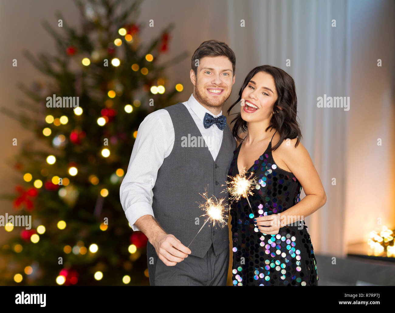 happy couple with sparklers at christmas party Stock Photo - Alamy