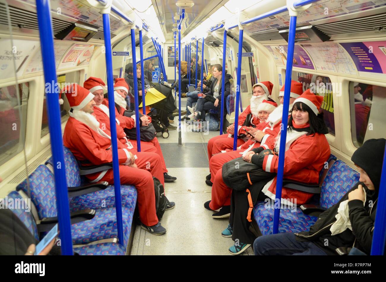 a group of santa claus dressed people on the london underground 2018 ...