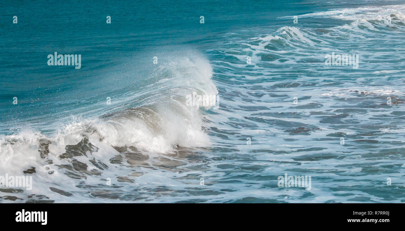 Blue wave crashing with white foam Stock Photo - Alamy