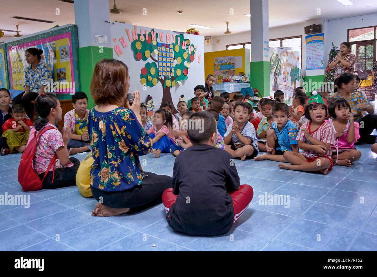 Thailand school. Teacher praying with young children in a Thai school ...