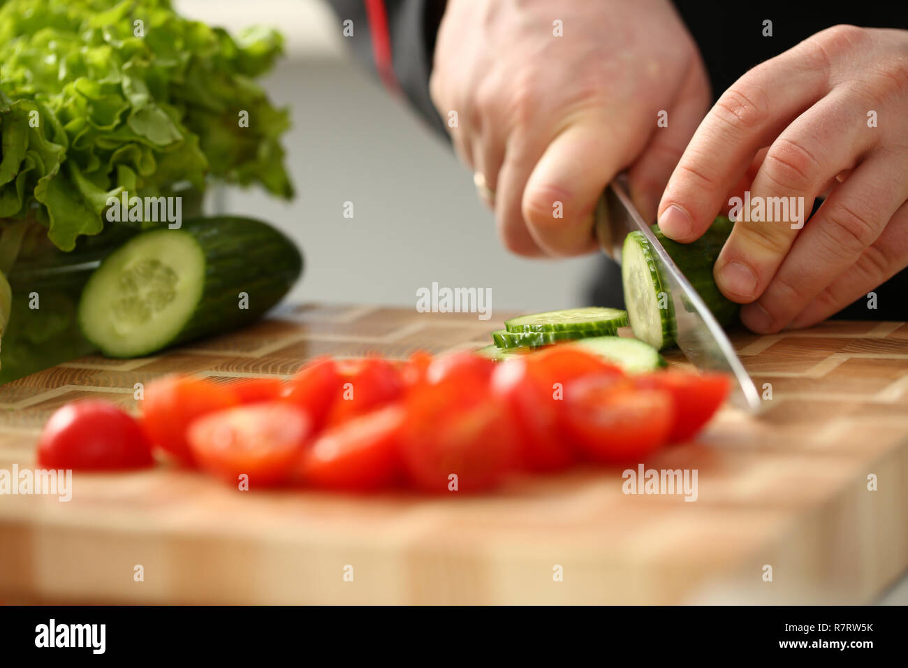 Cook holds knife in hand and cuts on Stock Photo - Alamy