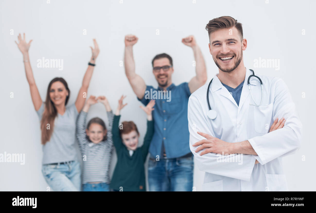 portrait of a family doctor on the background of his happy patients ...