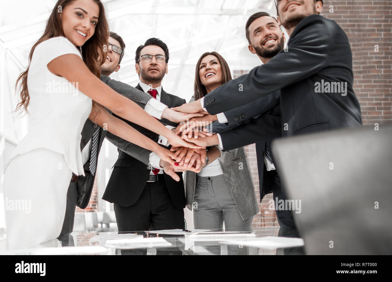 happy business team joining their hands together Stock Photo - Alamy