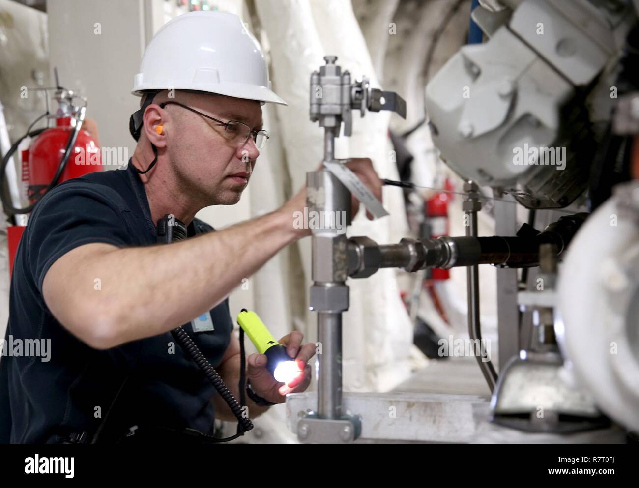 Sergey Amosov, USNS Trenton second engineer, inspects engine components ...