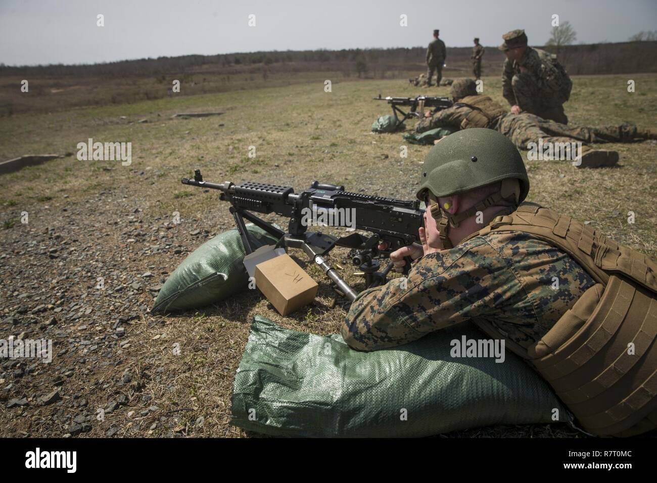A U.S. Marine with Headquarters and Service Battalion fires the M240B ...