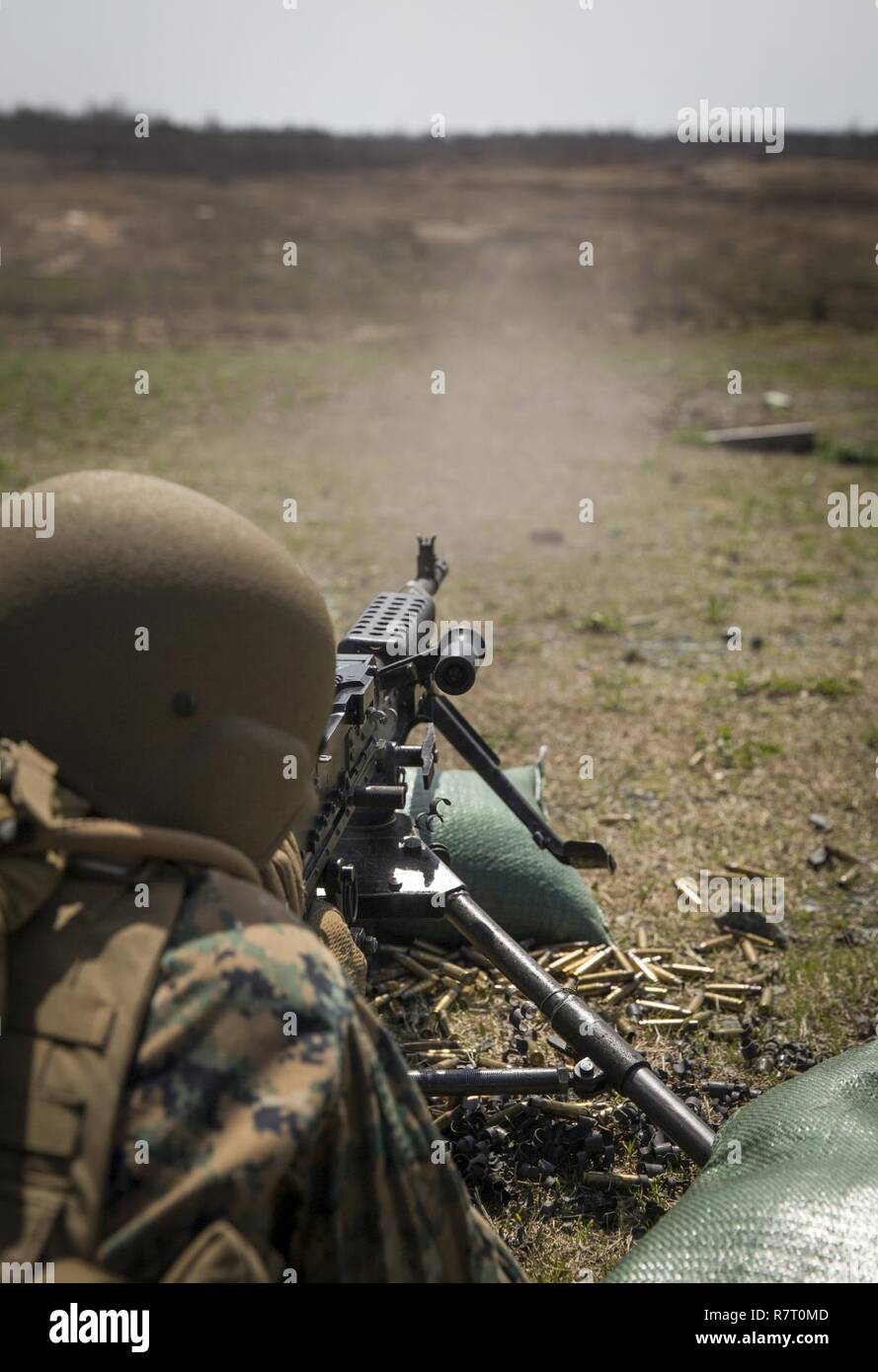 A U.S. Marine with Headquarters and Service Battalion fires the M240B ...