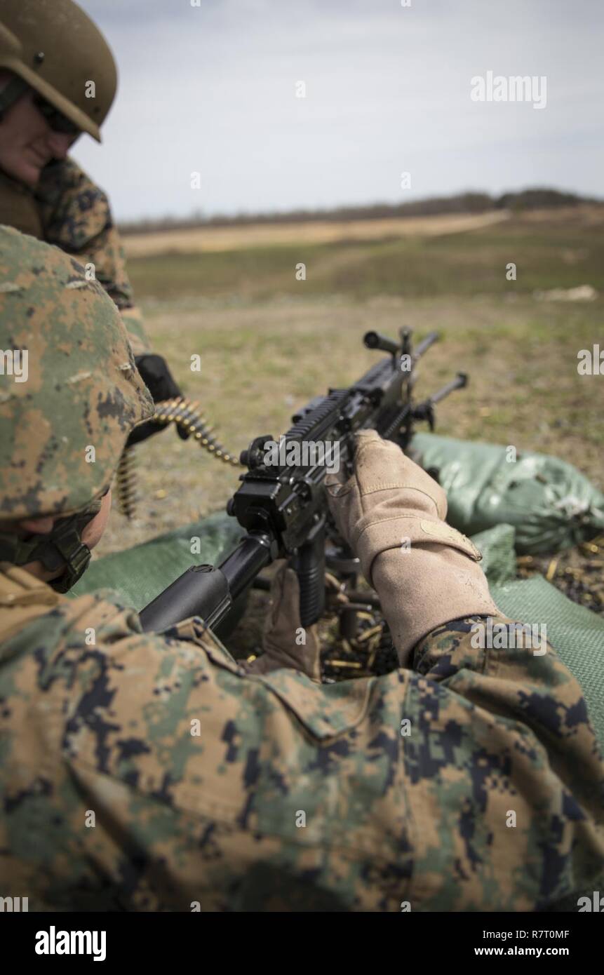 A U.S. Marine with Headquarters and Service Battalion fires the M240B ...