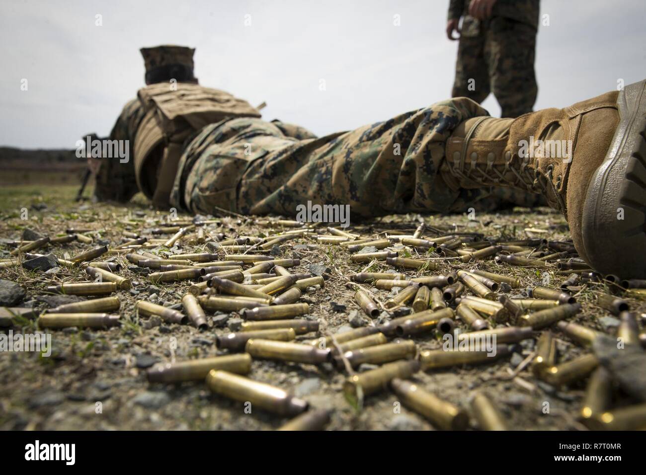 A U.S. Marine with Headquarters and Service Battalion fires the M240B ...