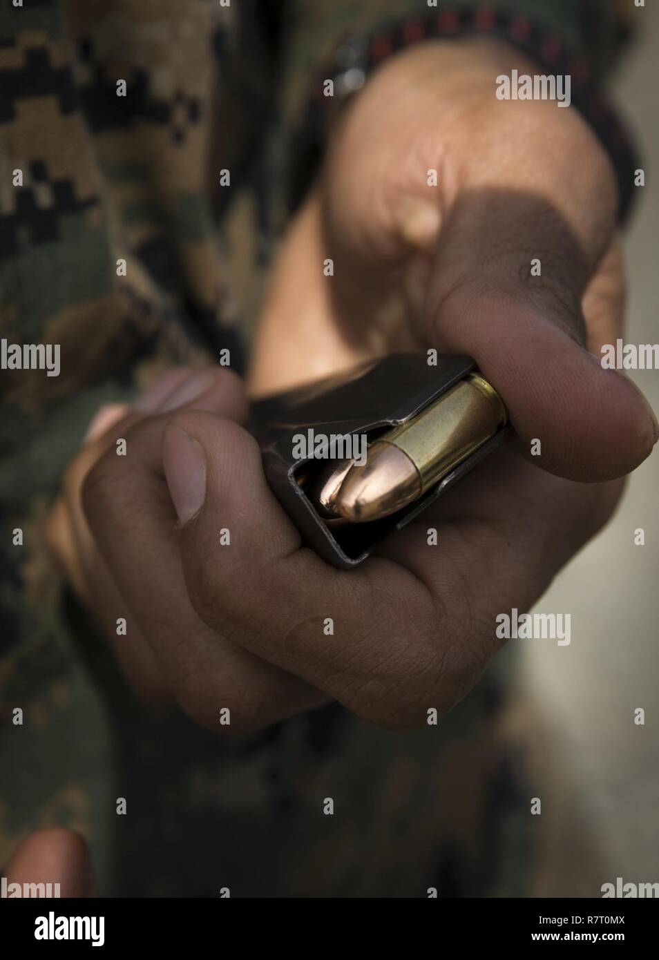 A U.S. Marine with Headquarters and Service Battalion loads an ...