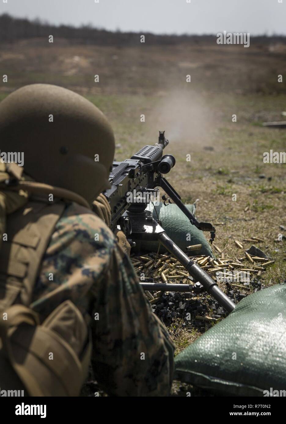 A U.S. Marine with Headquarters and Service Battalion fires the M240B ...