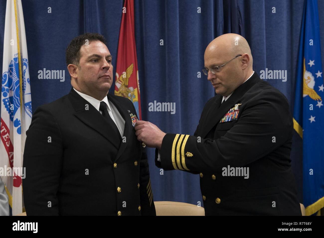 PORTSMOUTH, Va. (March 31, 2017)-Cmdr. Joseph Nellis pins the Navy ...