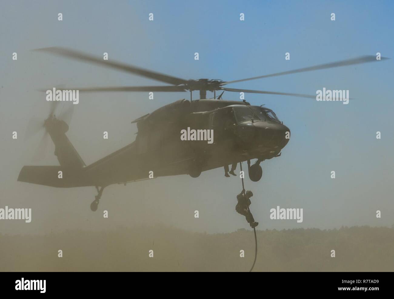 A U.S. Army Ranger fast ropes out of a UH-60 Black Hawk helicopter ...