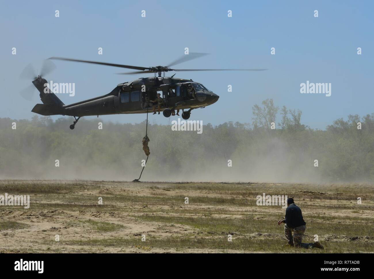 A U.S. Army Ranger fast ropes out of a UH-60 Black Hawk helicopter ...