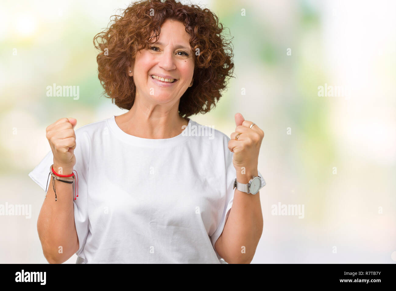 Beautiful middle ager senior woman wearing white t-shirt over isolated ...