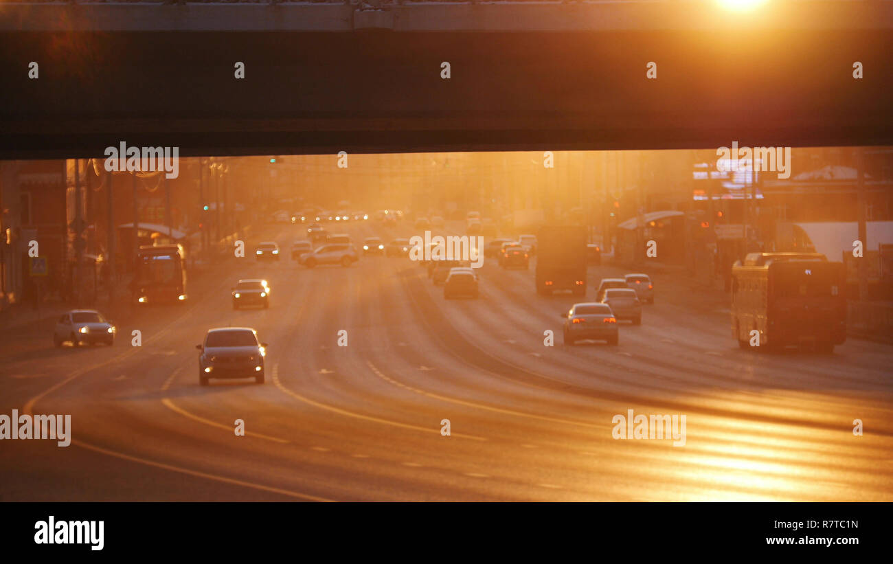 A big city. Cars riding on the road under the bridge. Sunset Stock ...