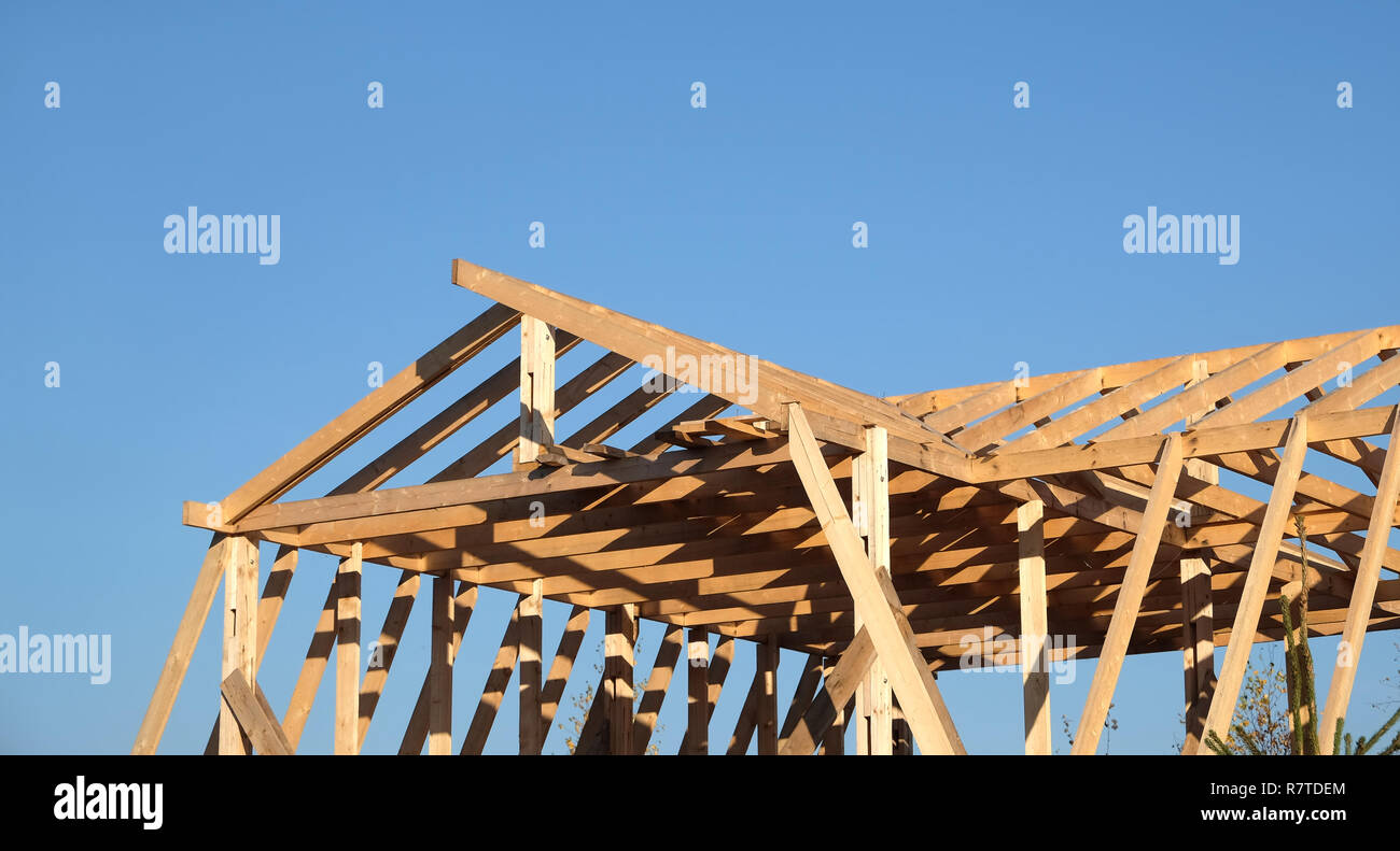 Process of wooden carcass house mounting ubder clear cloudless blue sky ...