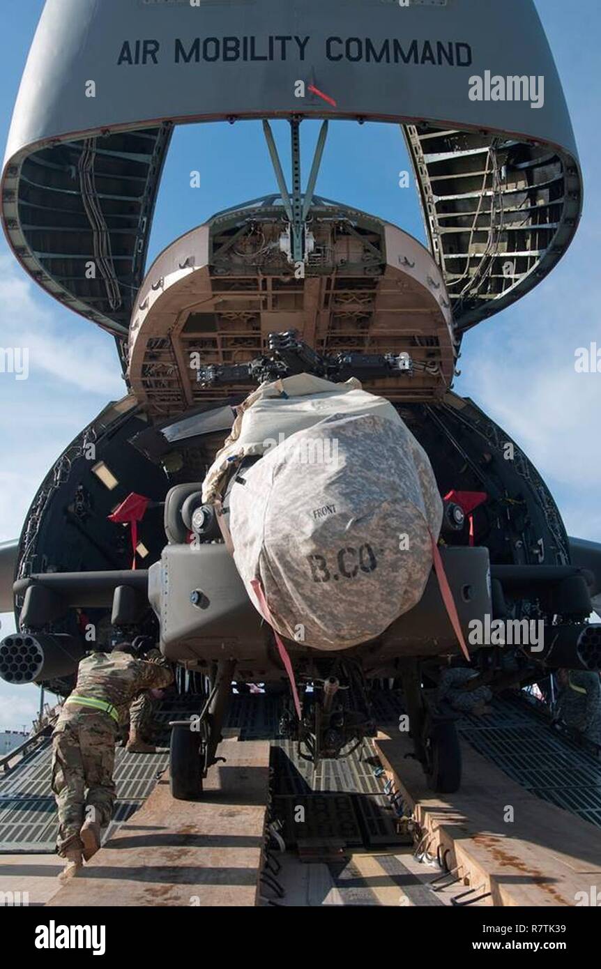 An AH-64 Apache helicopter is loaded onto a Team Dover C-5M Super ...