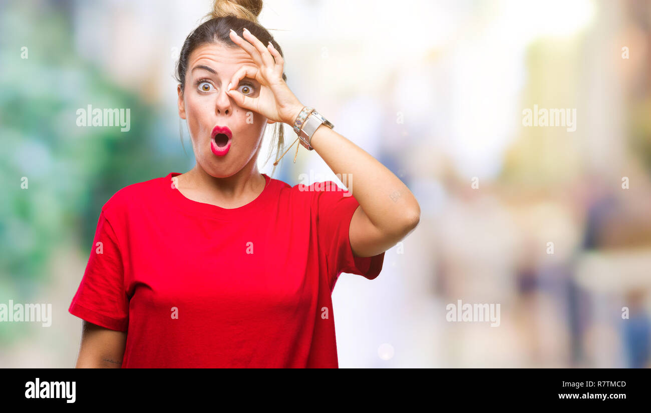 Young beautiful woman over isolated background doing ok gesture shocked ...