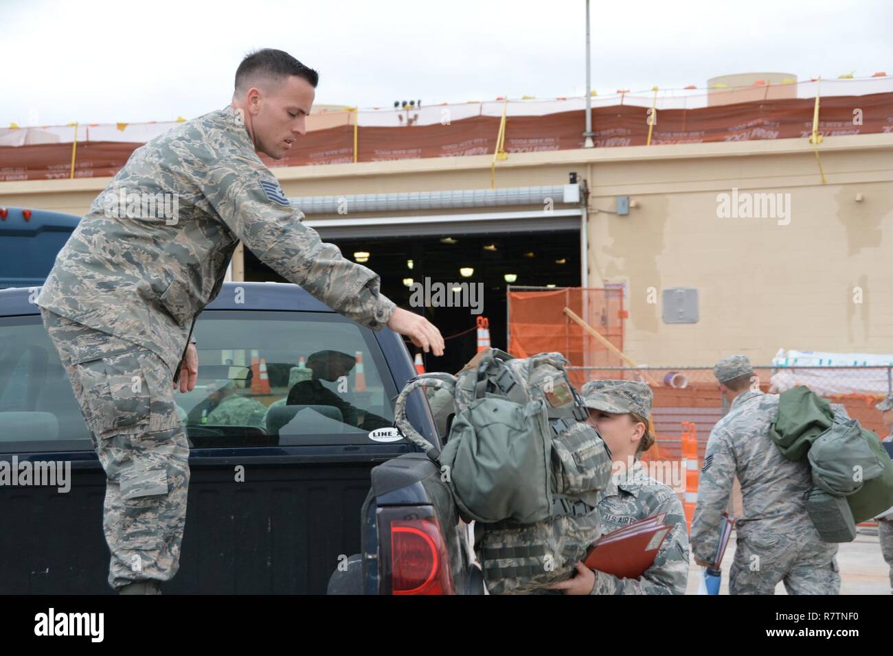 Citizen Airmen move bags for pre-deployment processing through the personnel deployment function ...