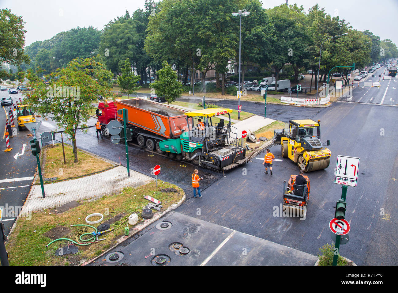Rolling machines and an asphalt spreader during asphalt work on a large ...