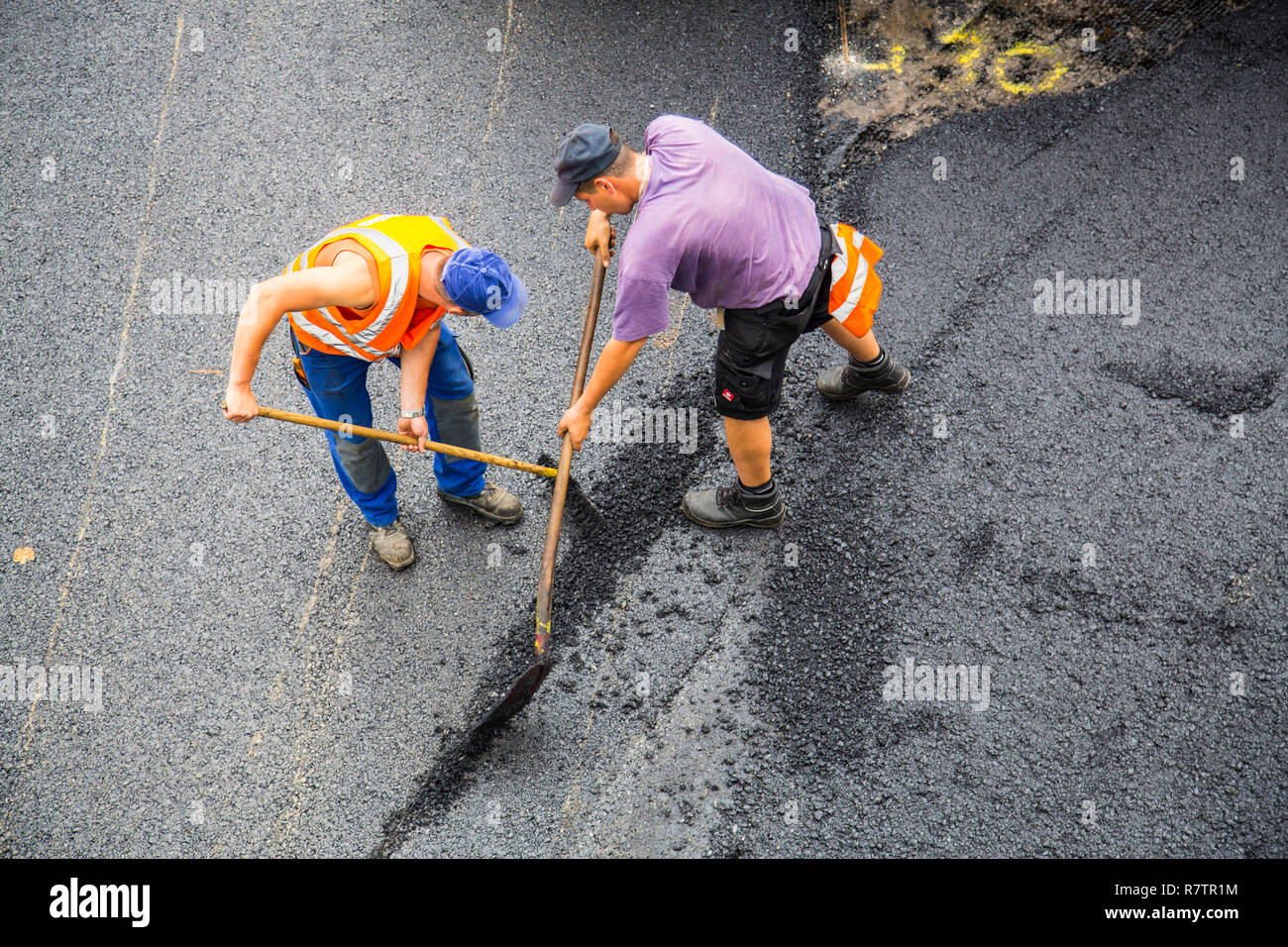 Road construction workers, tarmac laying works at a road construction ...