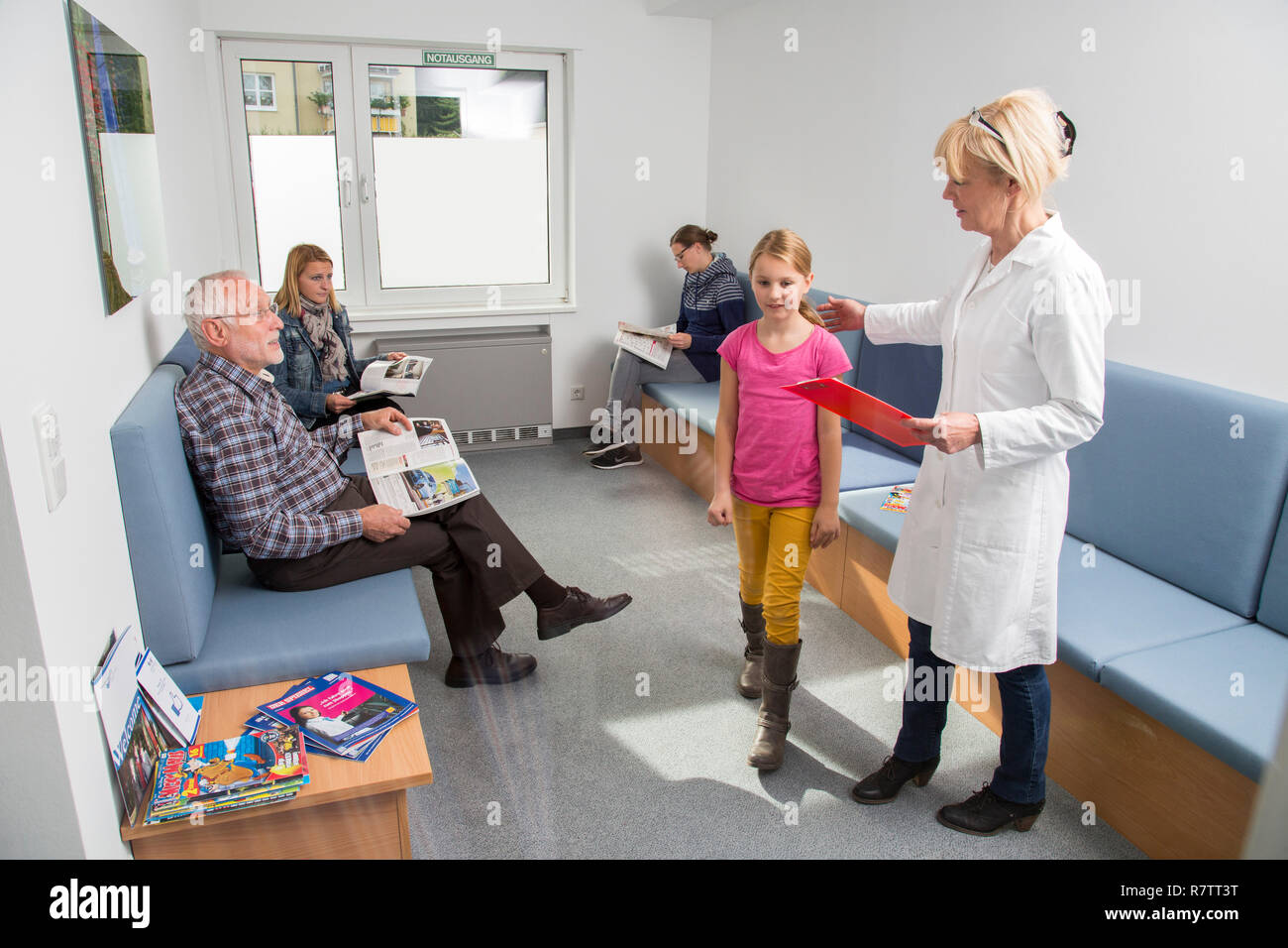 Receptionist calling for the next patient in the waiting room of a ...
