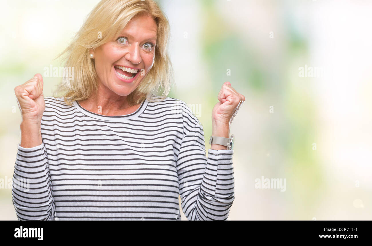 Middle age blonde woman over isolated background celebrating surprised and amazed for success ...