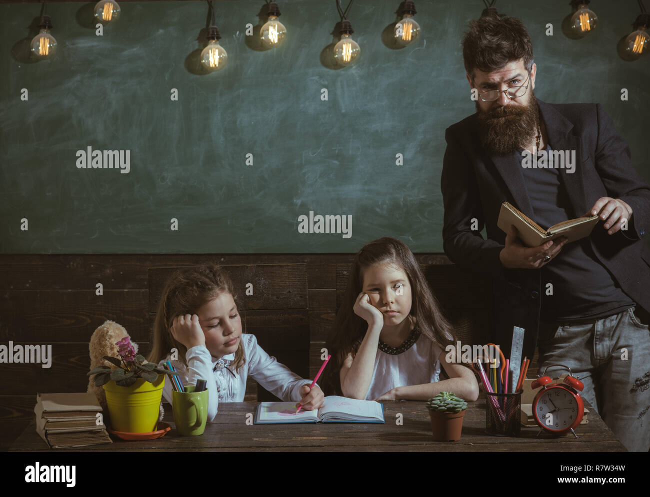 Boring lesson concept. Teacher and girls pupils in classroom ...