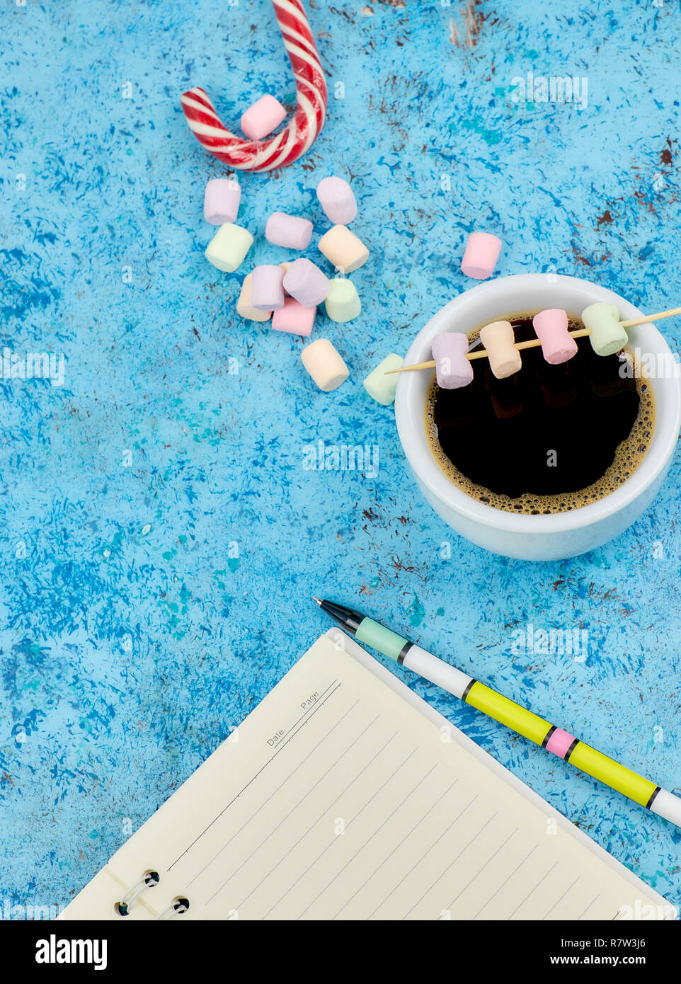 Cup with coffee and marshmallows, blank open notebook with pen on ...