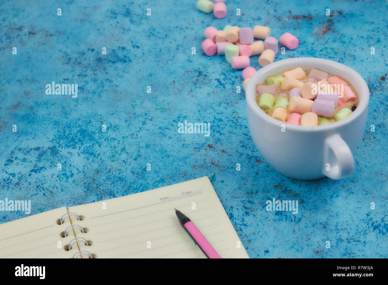 Cup with coffee and marshmallows, blank open notebook with pen on ...