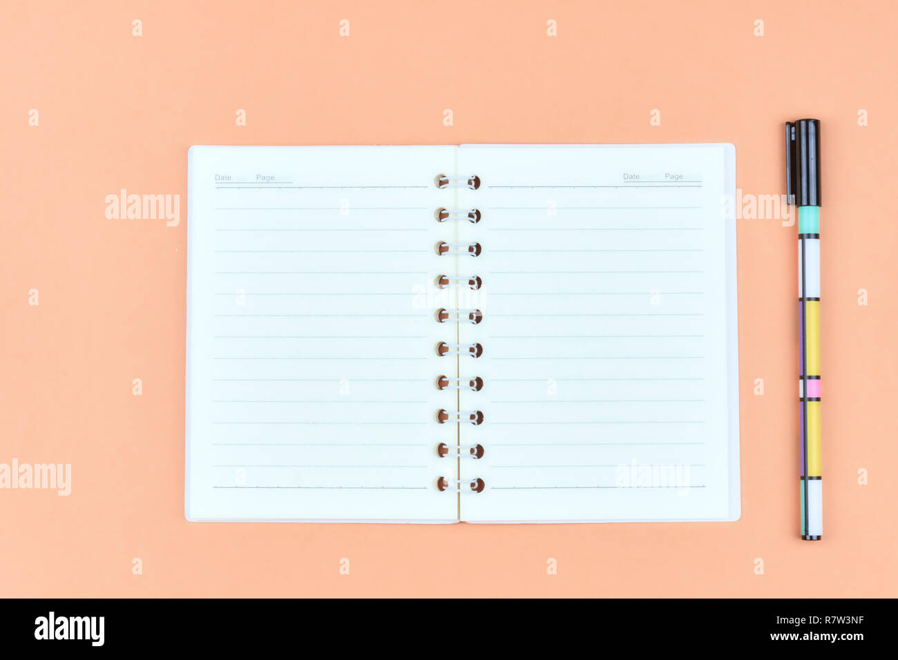 Blank notepad white page on pink desk, color background. Top view ...