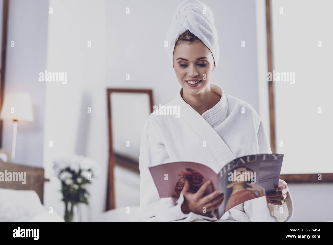 Young woman reading magazine article Stock Photo - Alamy