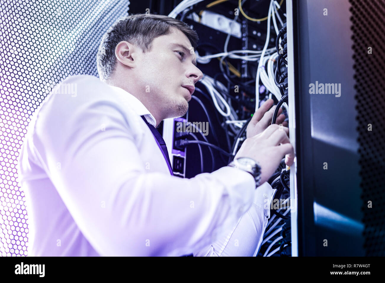 Intelligent young man standing near the box with wires Stock Photo - Alamy