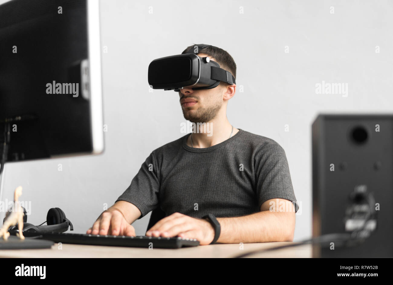 Young man wearing virtual reality goggles headset, vr box and sitting ...