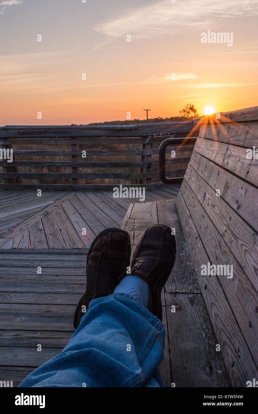 Feet up on bench enjoying the outdoors in the morning oceanfront ...