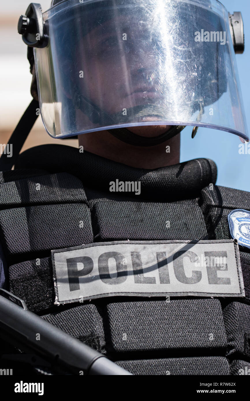 Riot police with tear gas , face shields and body armor gear up to ...