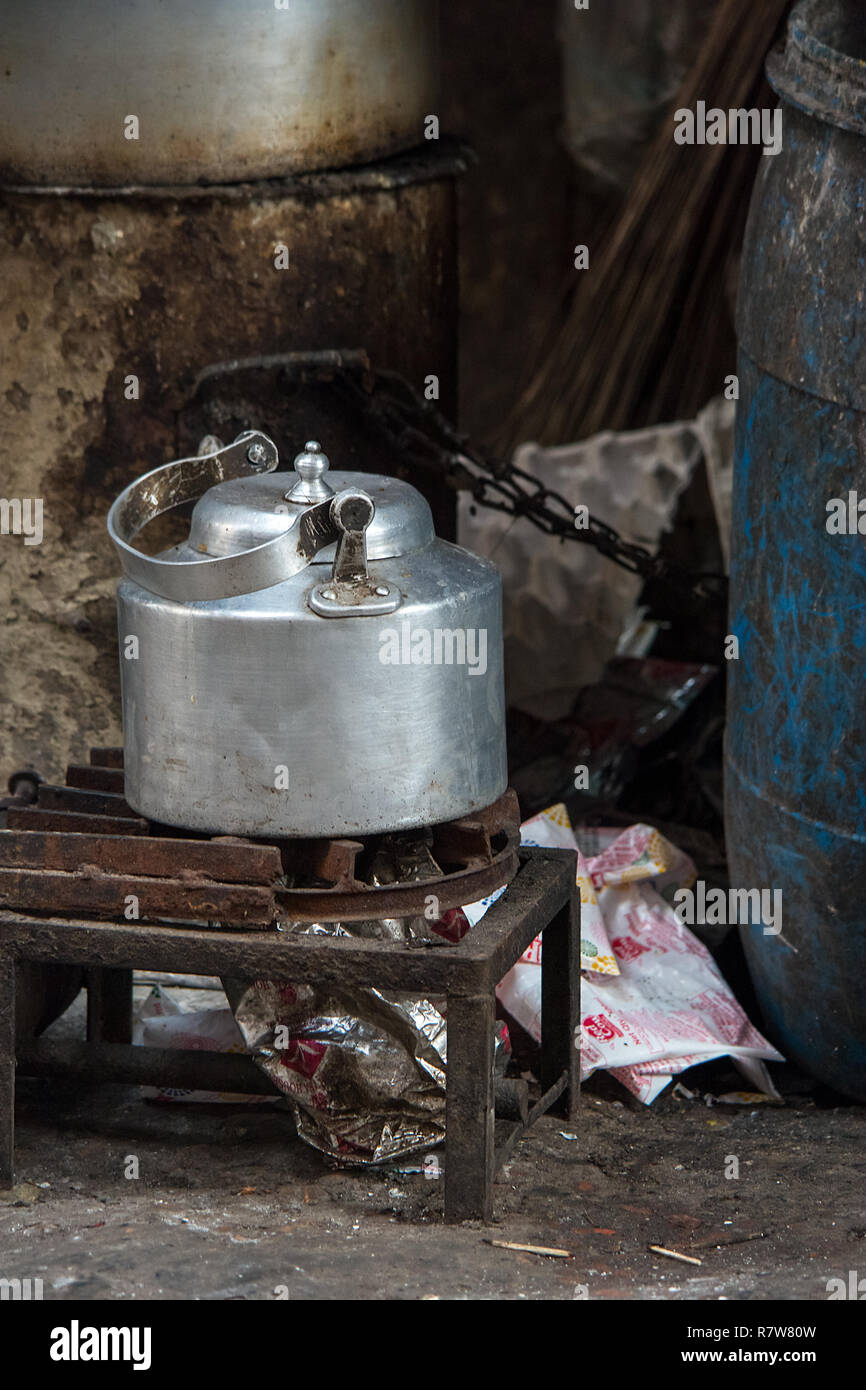 Large scale silver metal tea pot full of indian chai heating away in ...