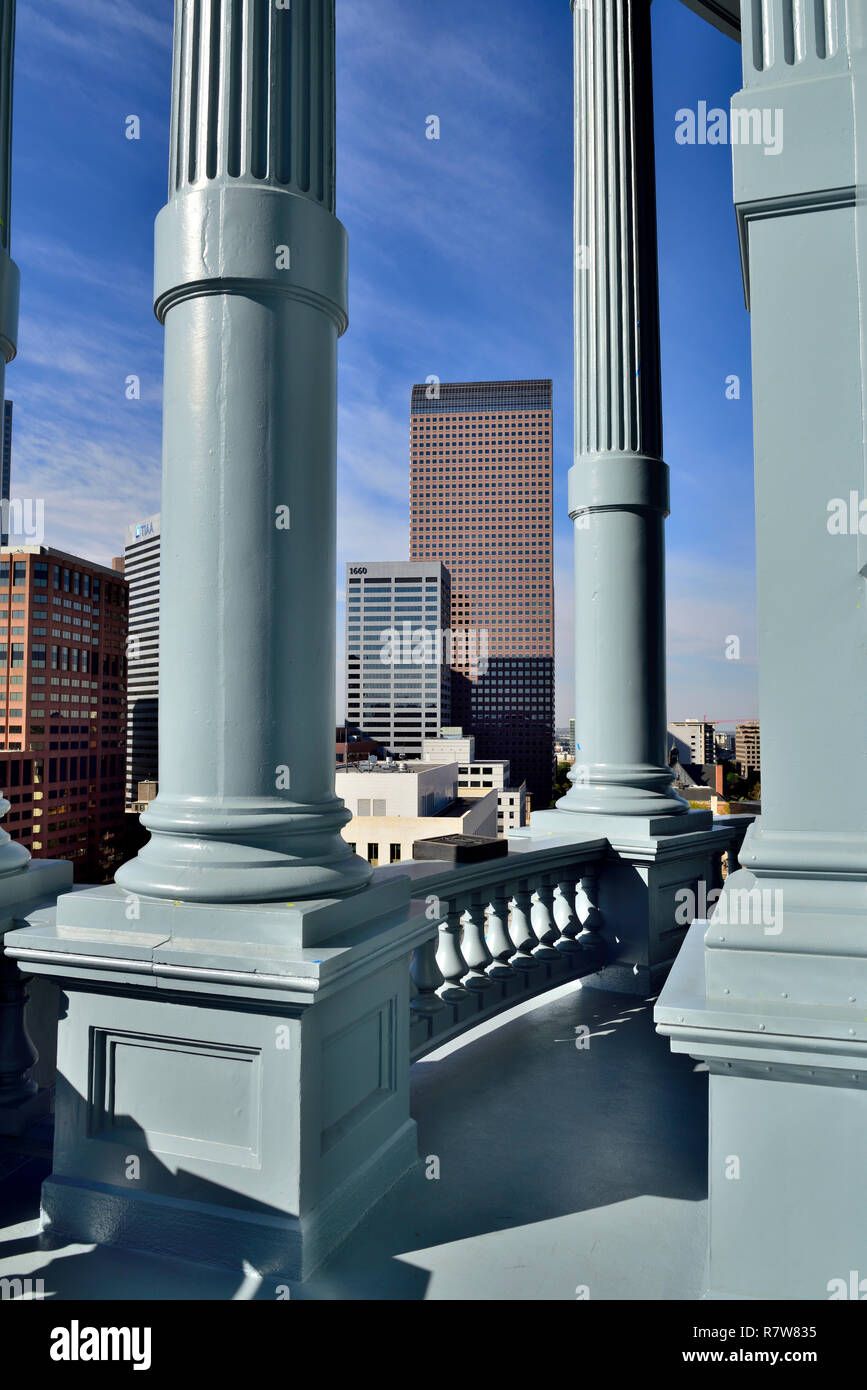 Looking between columns of Denver State Capital Building at skyscrapers ...